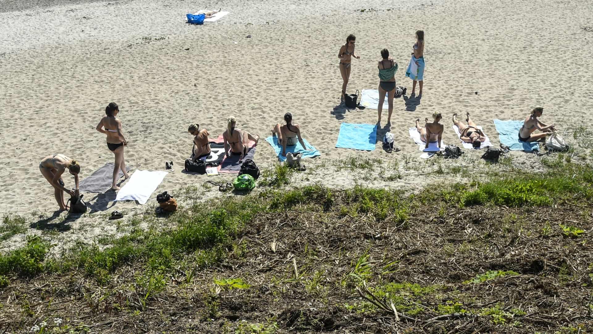 Midaldrende mand med topmave smilede til ung kvinde på stranden ...